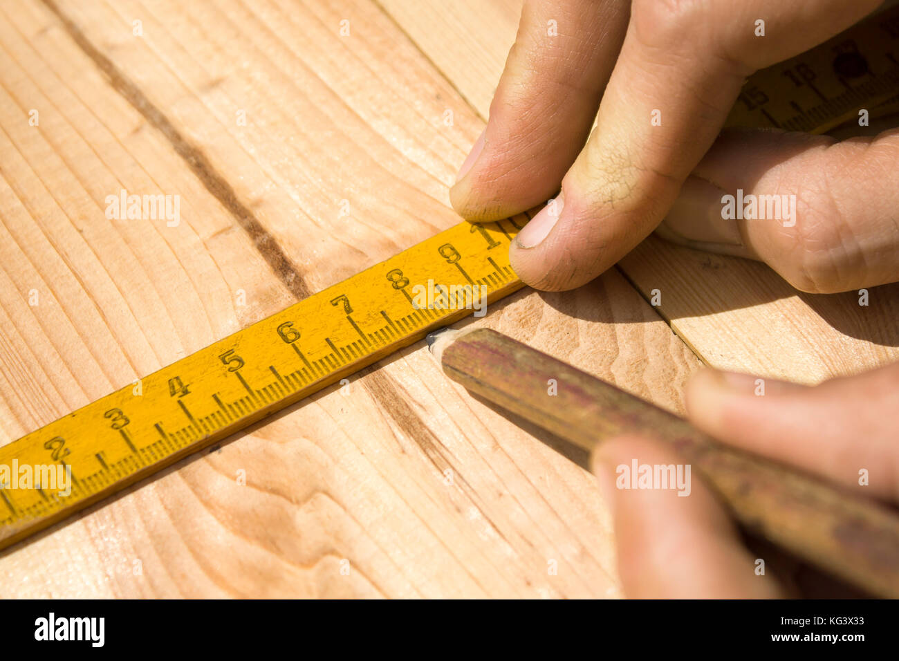 The carpenter measures the distance using a measure and marks with a ...