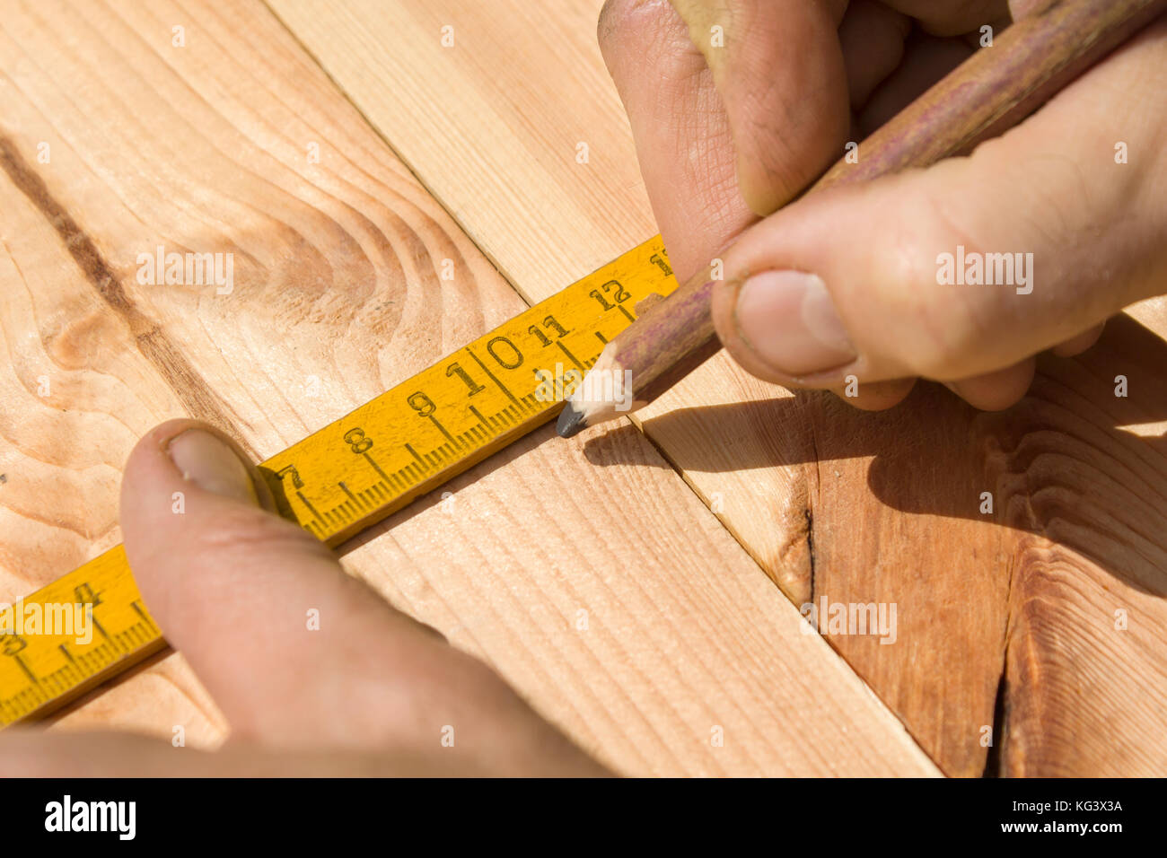 The carpenter measures the distance using a measure and marks with a ...