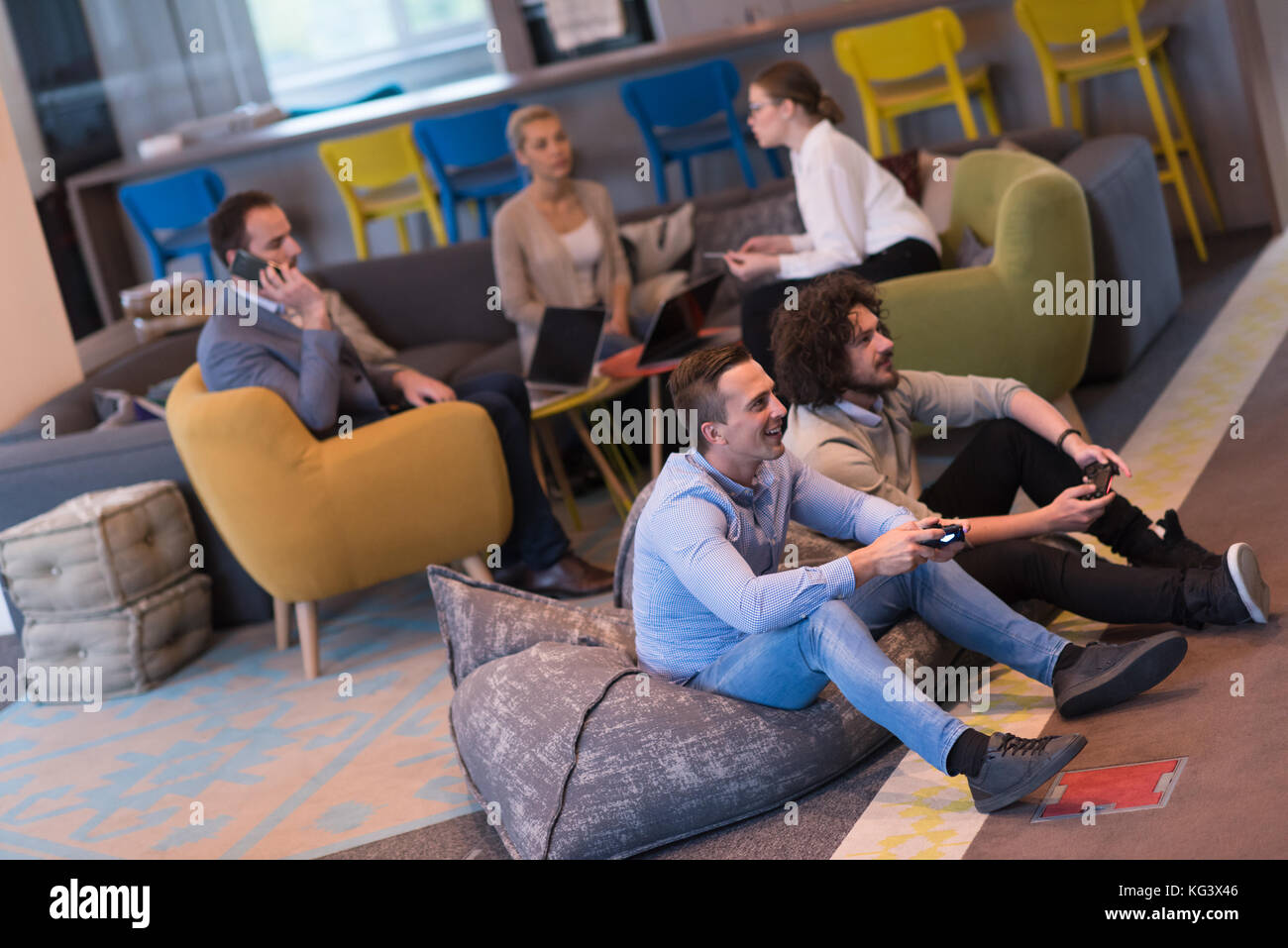 Work hard play hard. Workers Playing computer games in creative startup ...