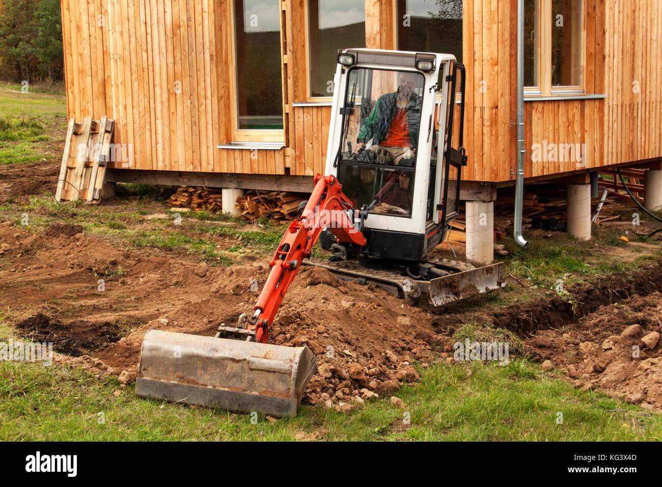 Work on the construction site of an ecological house. The excavator ...