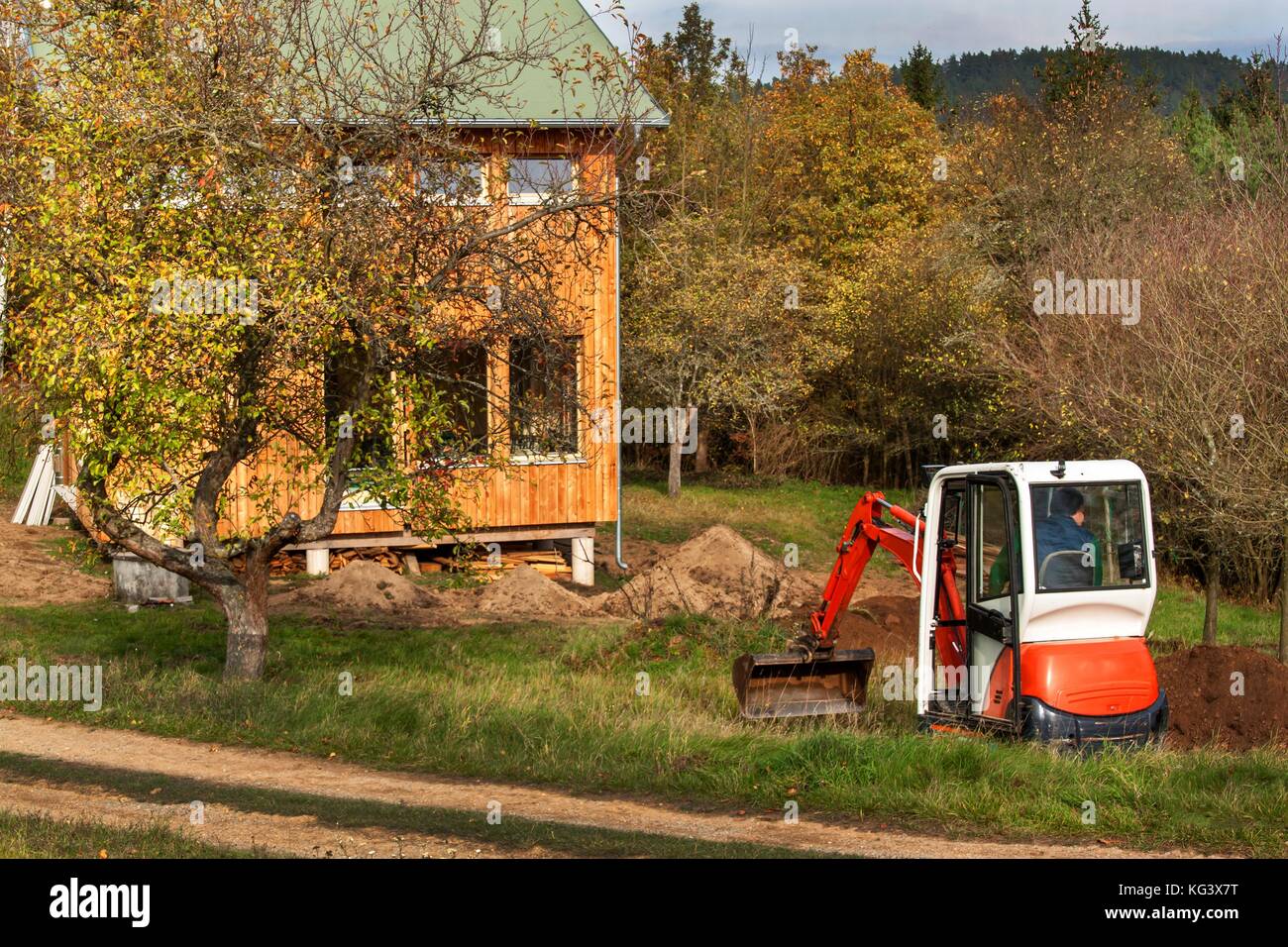 Work on the construction site of an ecological house. The excavator ...
