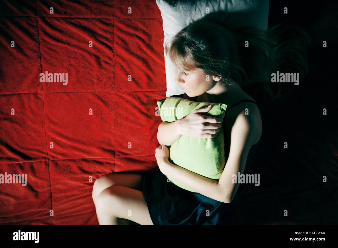 Young woman lying lonely in bed, intentionally toned Stock Photo - Alamy