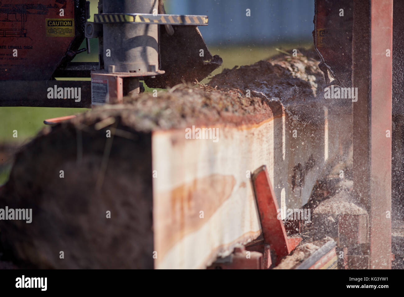 Large portable industrial saw cutting planks of lumber in the process ...