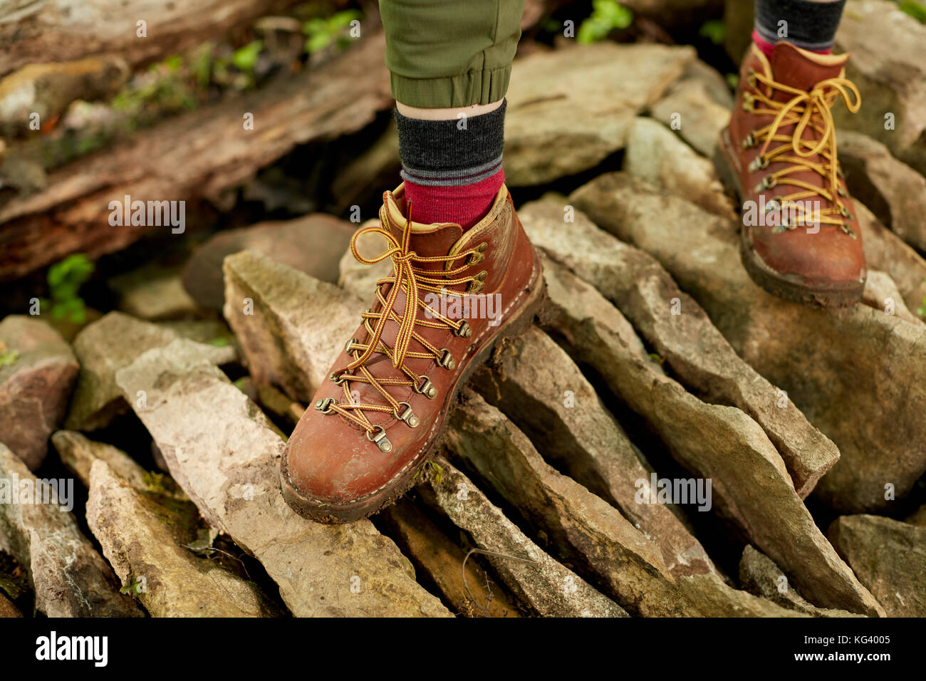 Feet of person in brown hiking boots walking over stones Stock Photo ...