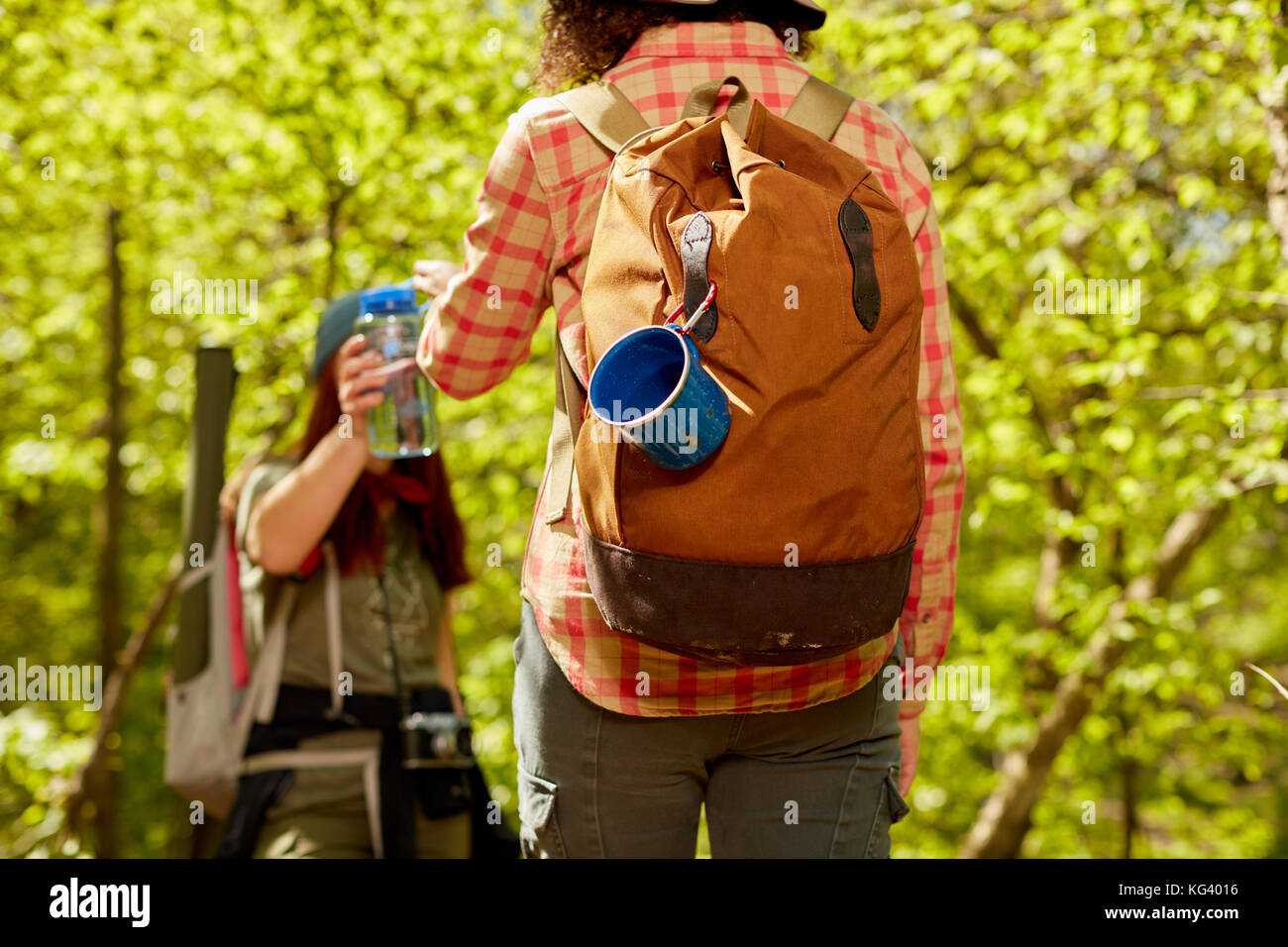 Two women hikers pausing for a drink from a flask in a closeup view of ...