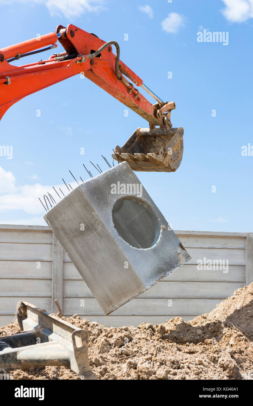 Excavator lift a manhole at construction site Stock Photo - Alamy