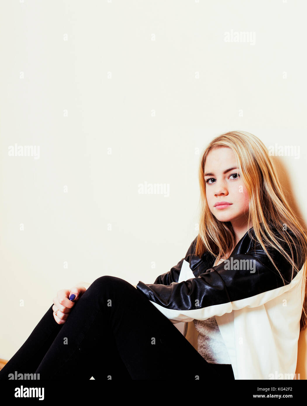 young pretty teenage blond girl sitting on floor at home despair Stock ...