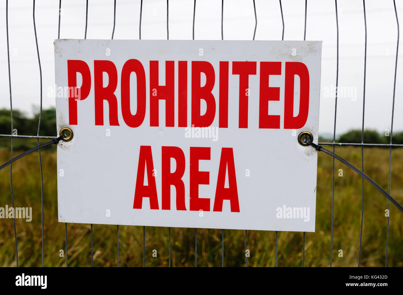 Sign on a fence beside a field "Prohibited Area Stock Photo - Alamy