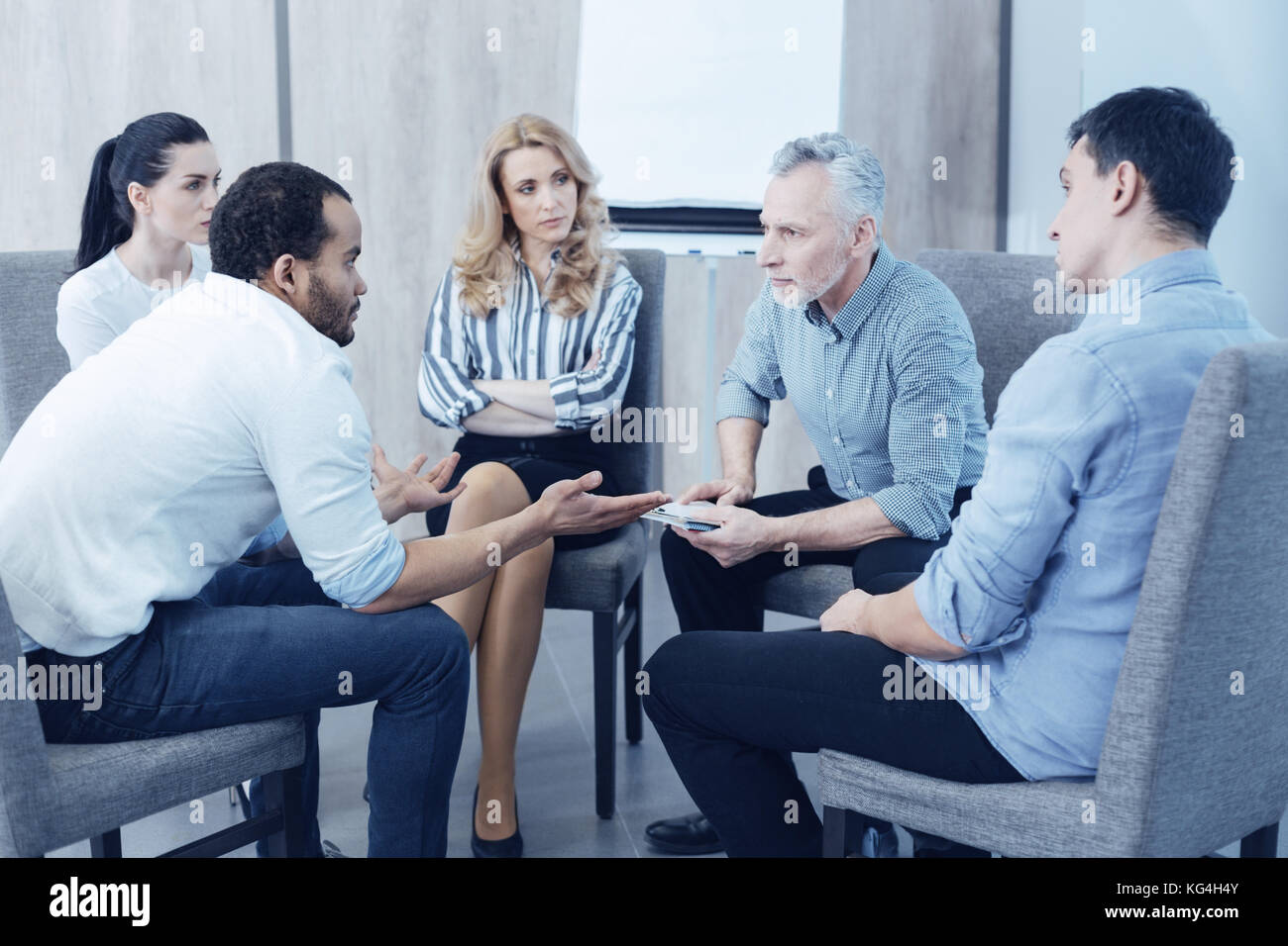Attentive blonde listening her colleagues Stock Photo - Alamy