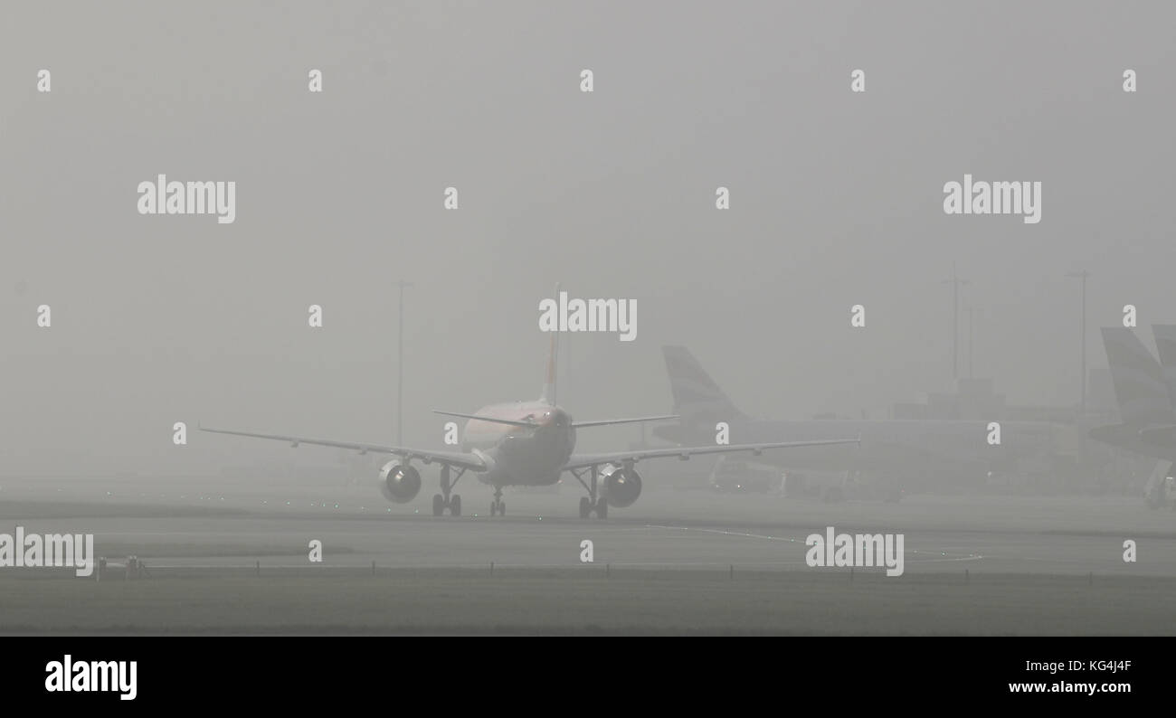 Planes are barely visible in the fog at Heathrow Airport's Terminal 5 ...