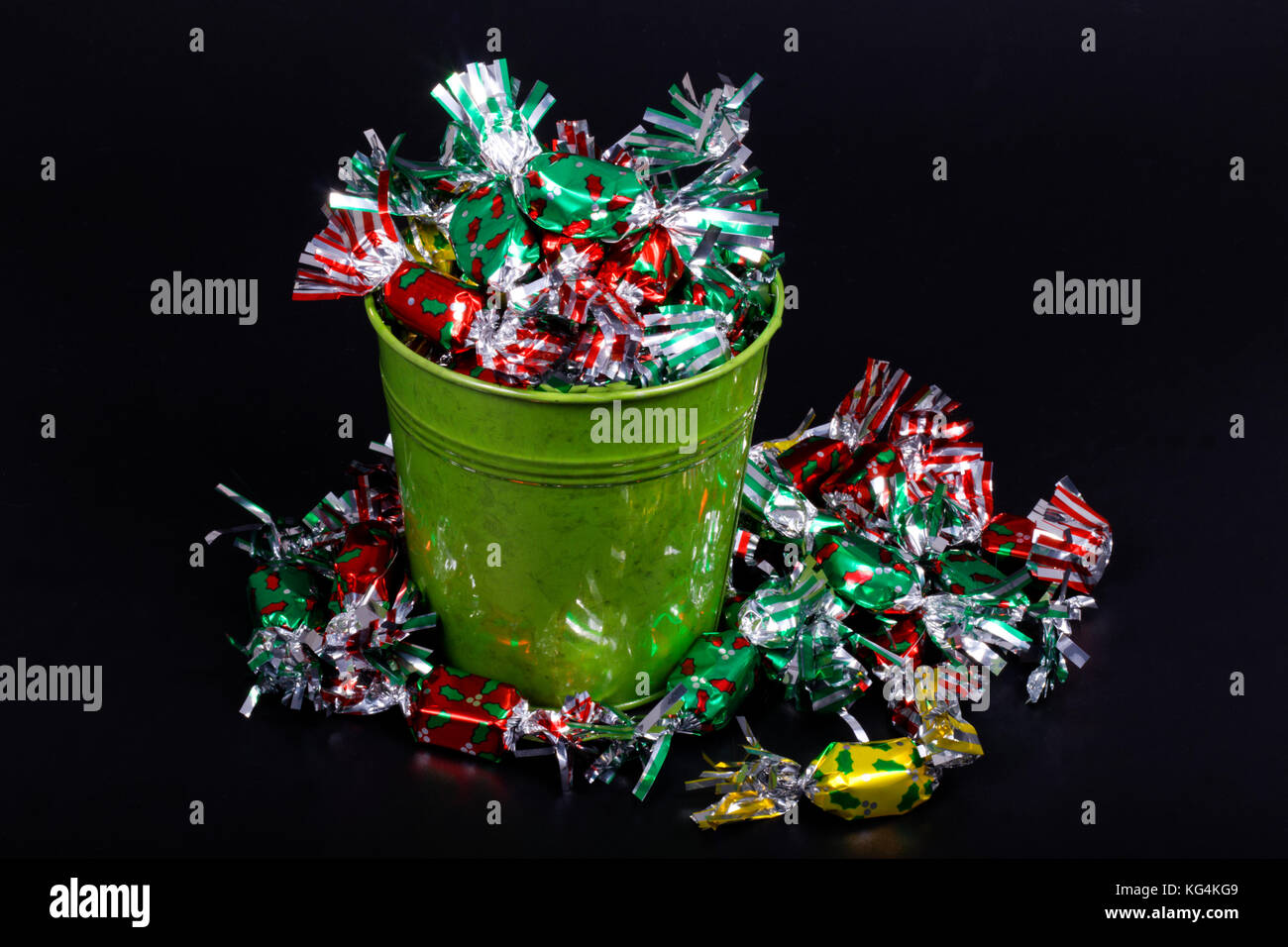 Colorful candy and green bucket on black background Stock Photo - Alamy