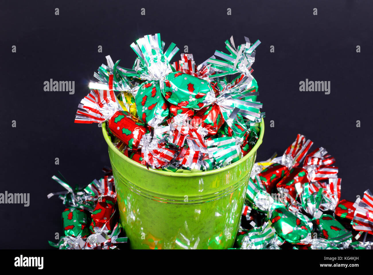 Colorful candy and green bucket on black background Stock Photo - Alamy
