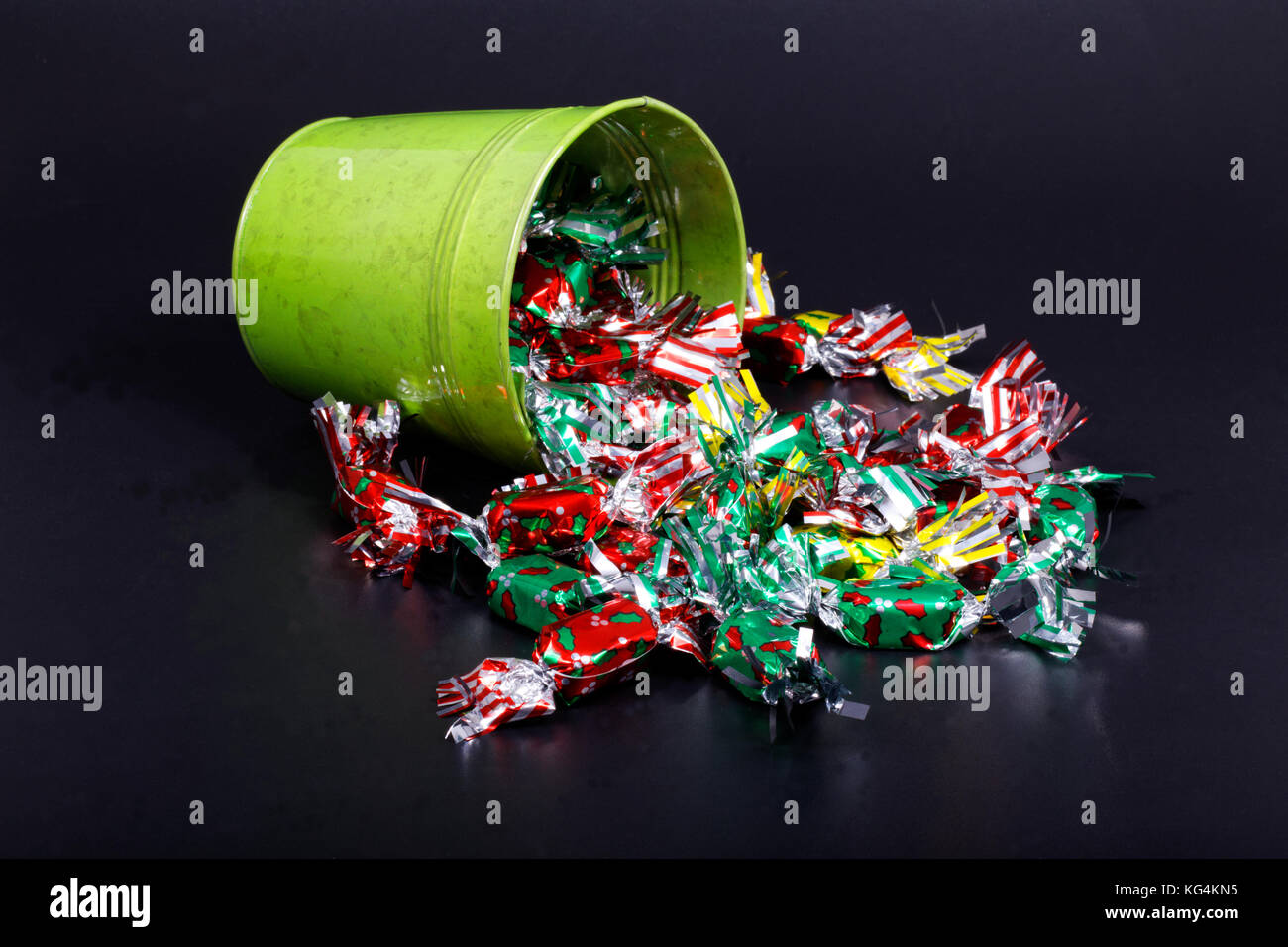 Colorful candy and green bucket on black background Stock Photo - Alamy