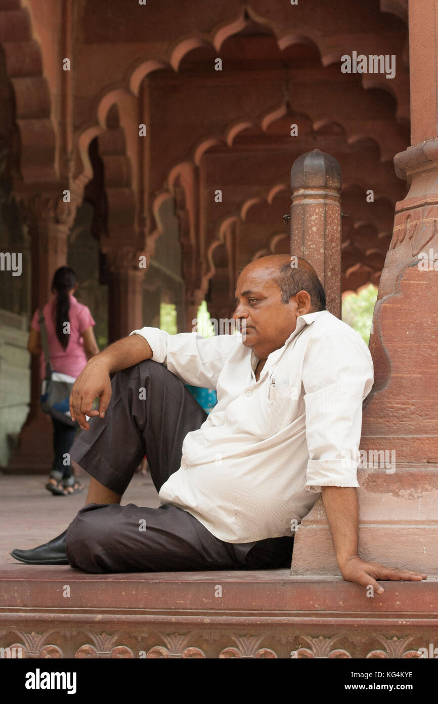 Man sitting leaning on column in front of arched colonnade, India Stock ...