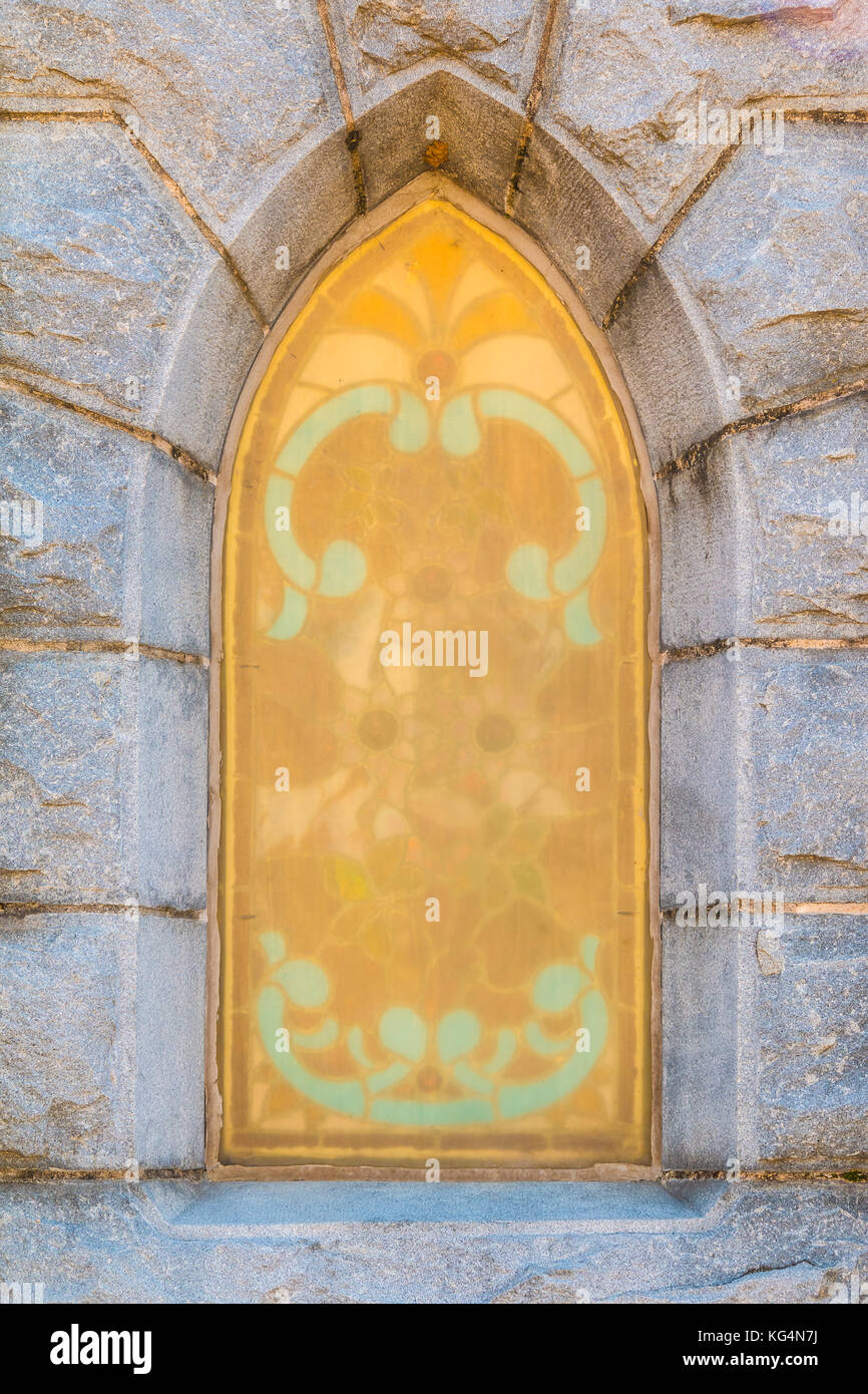 The stained-glass window on the facade of the stone crypt closeup front ...