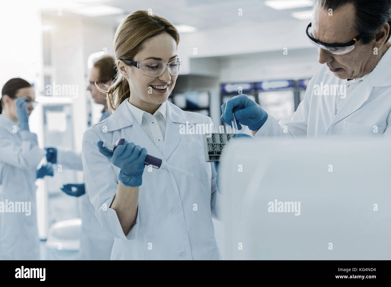 Cheerful positive woman working with colleagues Stock Photo - Alamy