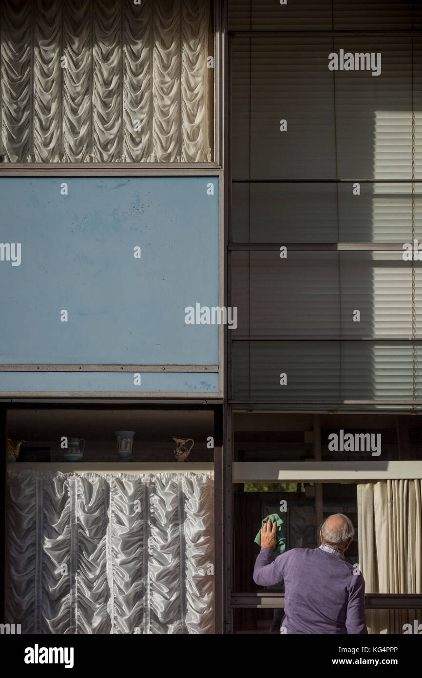 A resident of Bowater House on the Golden Lane Estate cleans a window ...