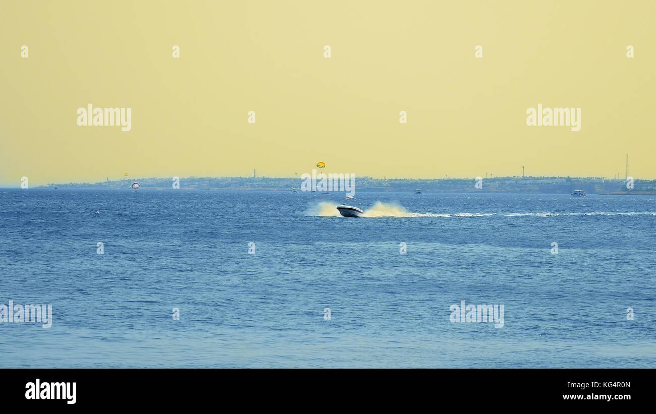 Powerboat ship sails at sunset along tropical sea Stock Photo - Alamy