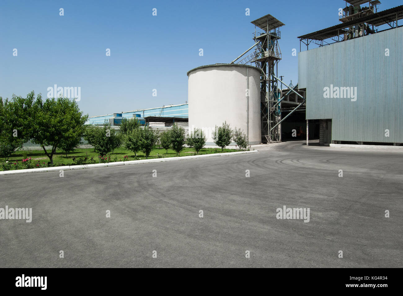 storage tank and a building on a farm under a blue sky. heavy ...
