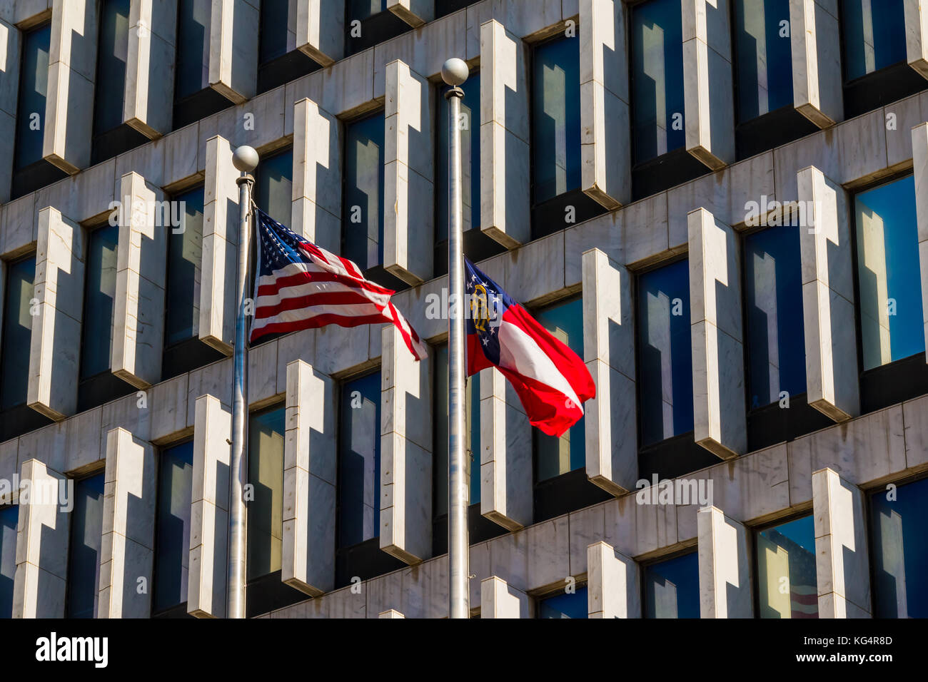 The flags of USA and Georgia on the background of facade of the office ...