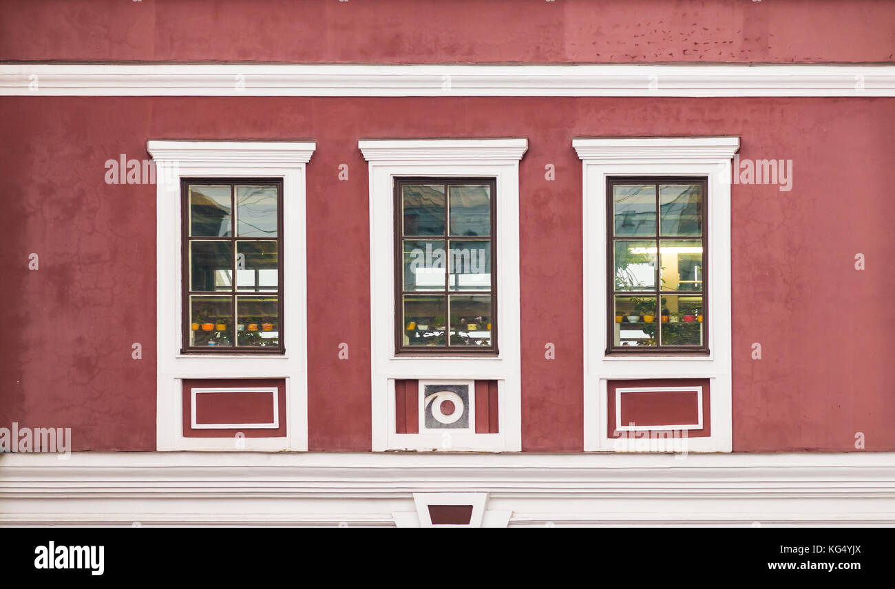 Three windows in a row on facade of urban office building front view ...