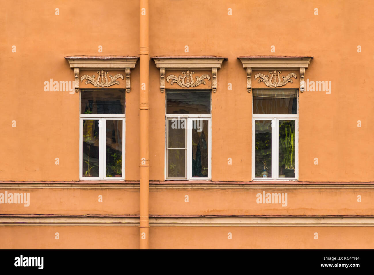Three windows in a row on facade of urban apartment building front view ...