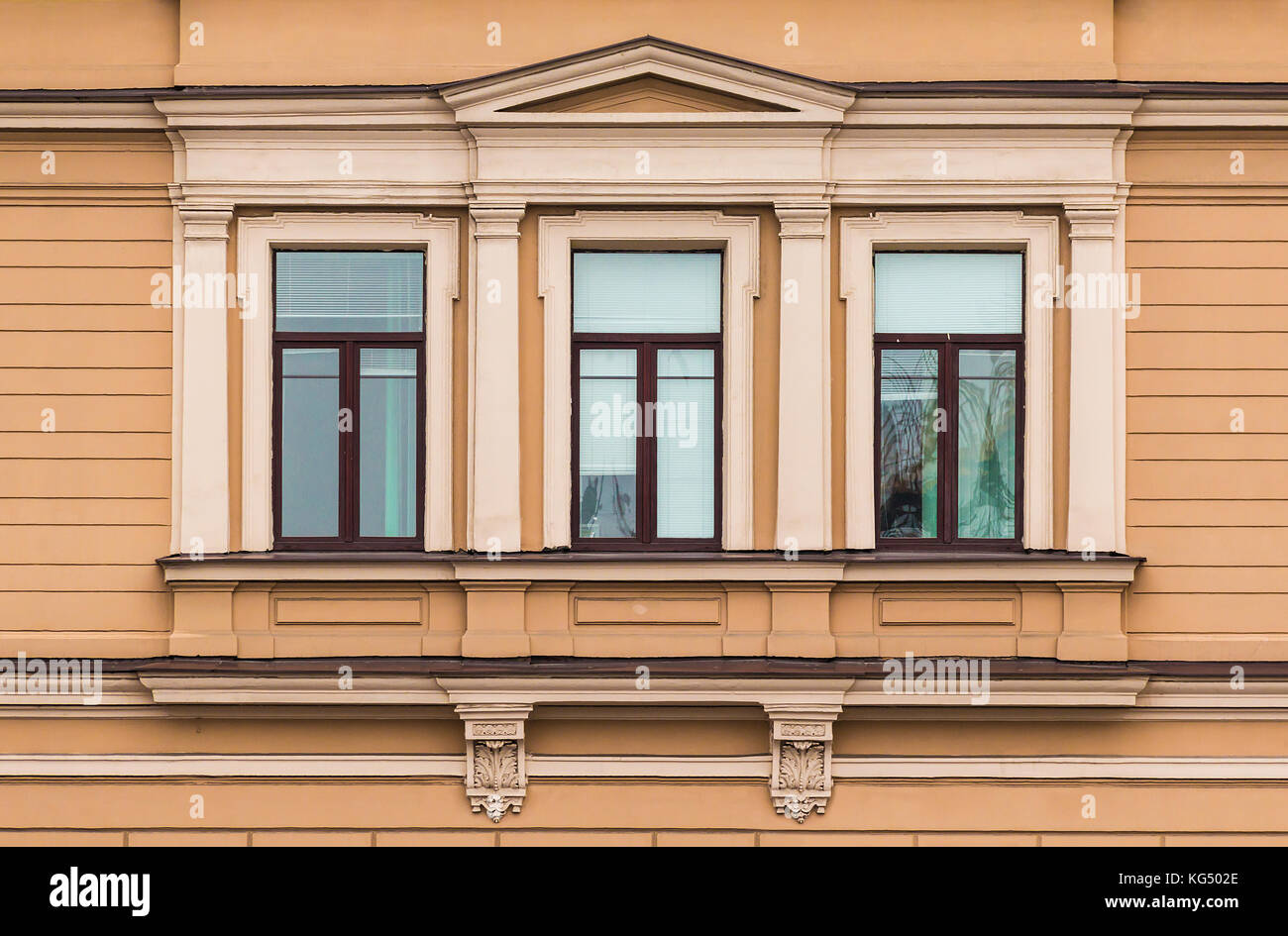 Three windows in a row on facade of urban office building front view ...