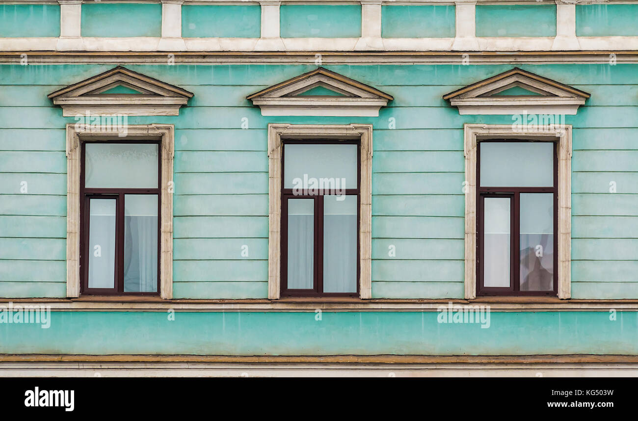 Three windows in a row on facade of urban apartment building front view ...