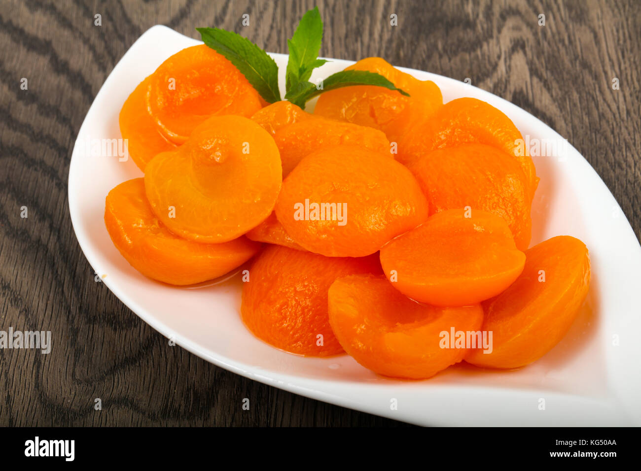 Canned apricots with mint leaves Stock Photo - Alamy