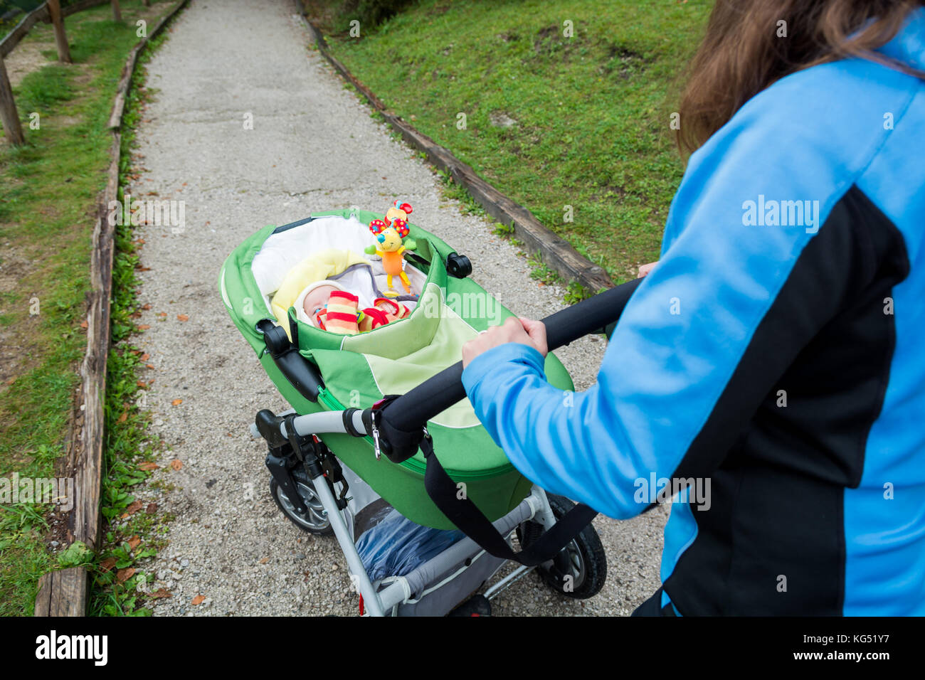 Mother pushing baby in a stroller Stock Photo - Alamy