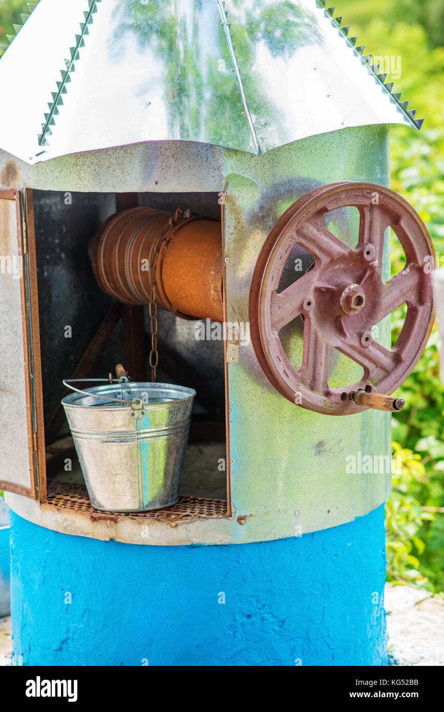 a well with water and a metal bucket near him Stock Photo - Alamy