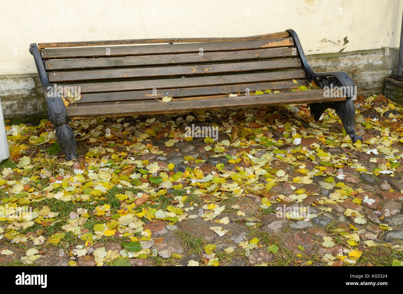 A wooden bench stands against the wall all wet from the rain Stock ...