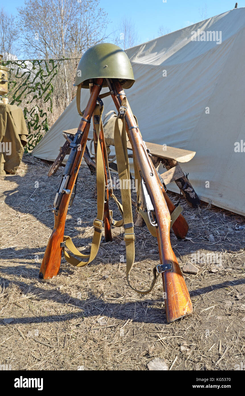 Protective helmet of a soldier hanging on military rifles Stock Photo ...