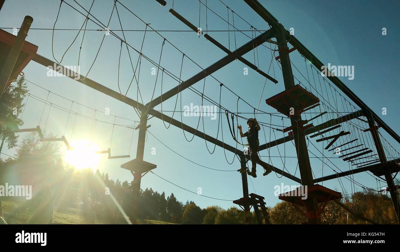 Unidentifiable boy climbing in high rope park Stock Photo - Alamy