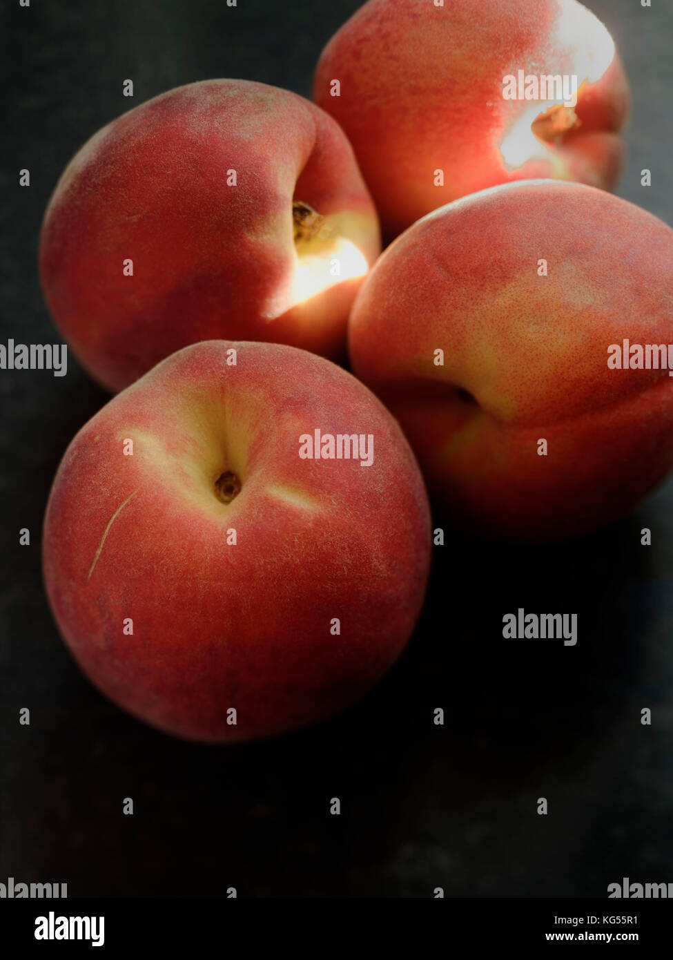 Four peaches on dark background Stock Photo - Alamy