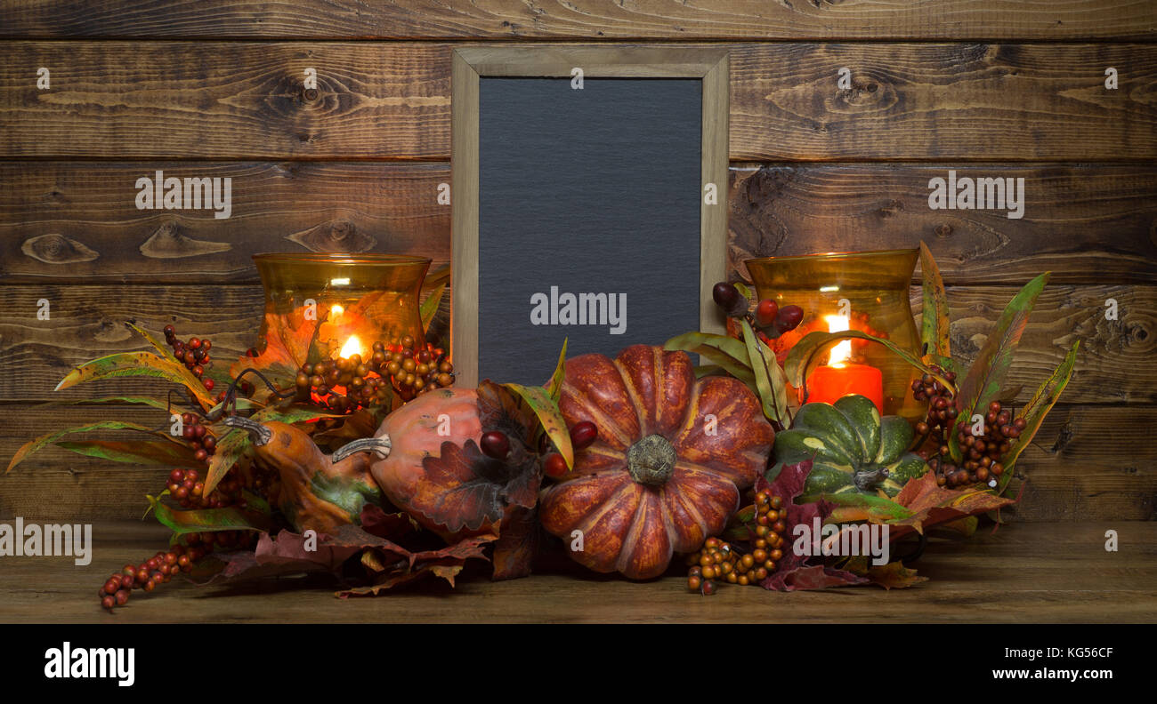 Autumn candle decoration on a rustic wood background with copy space ...