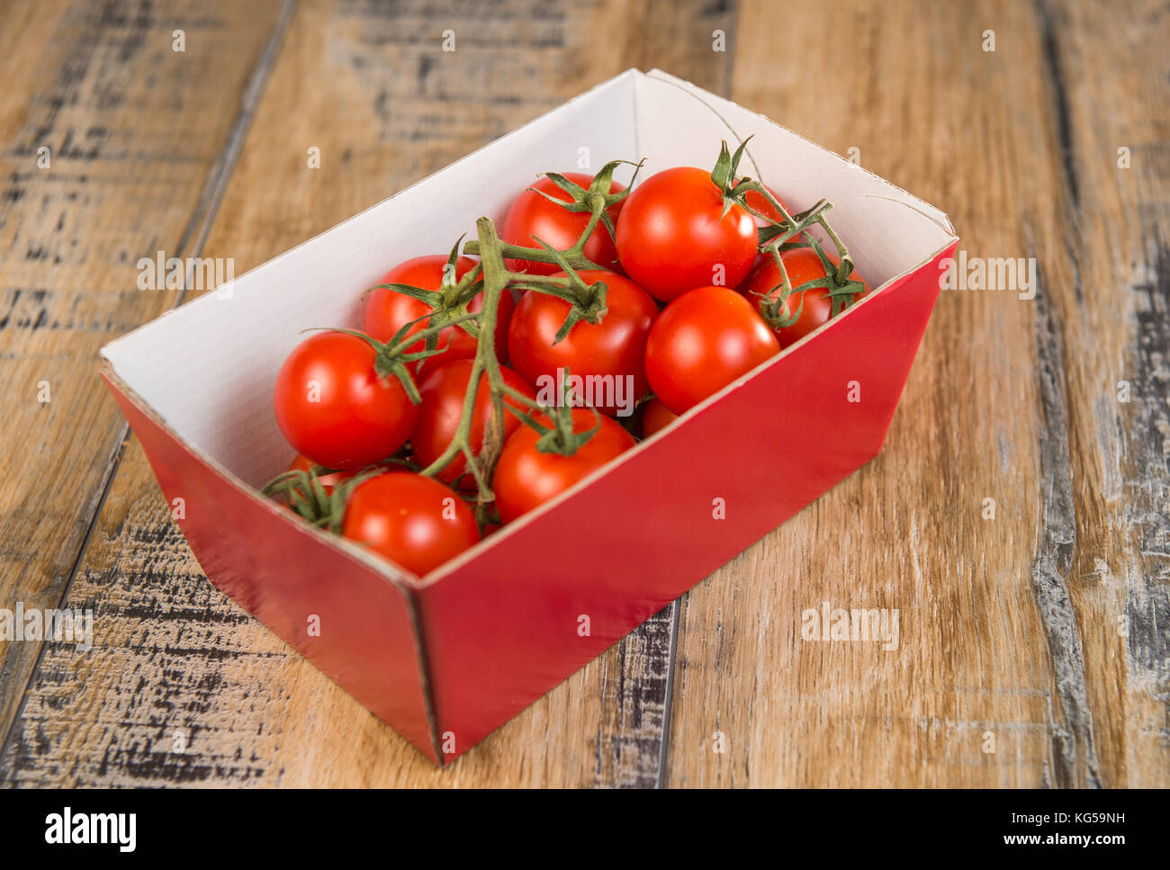 Fresh cherry tomatoes on cardboard box and wooden background, France ...