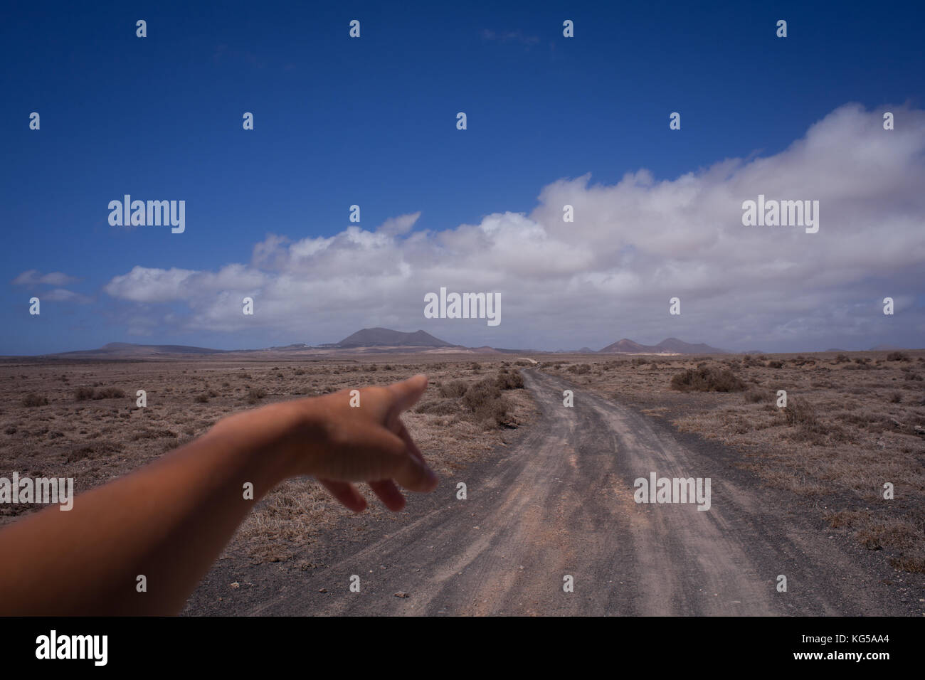 Female hand indicating destination on a empty road Stock Photo - Alamy