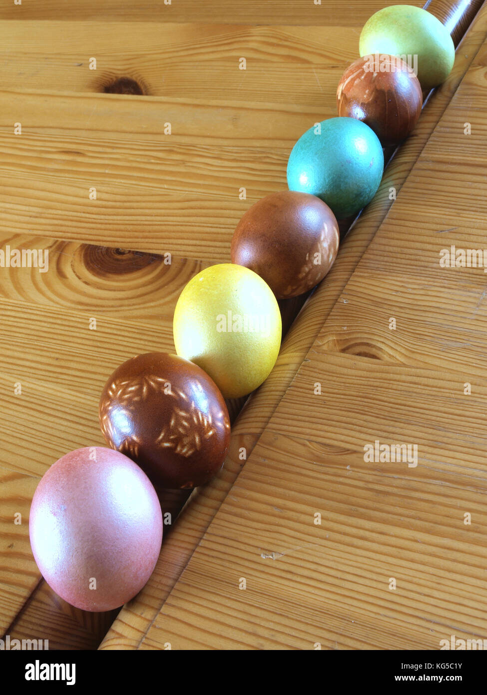Different color easter eggs diagonal row on wooden table Stock Photo ...