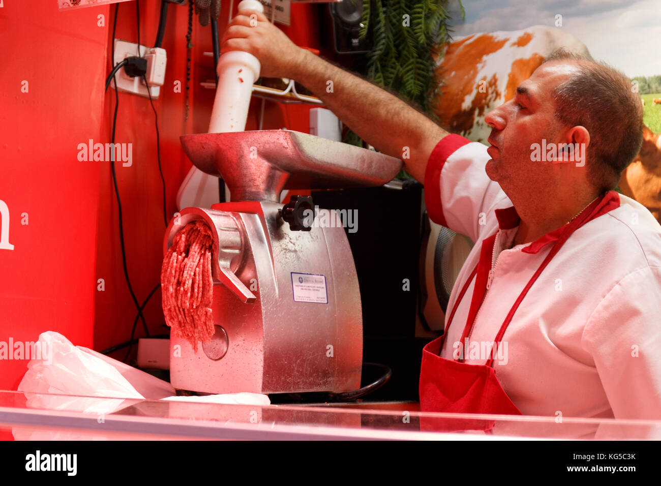 butcher chopping meat with a machine Stock Photo - Alamy