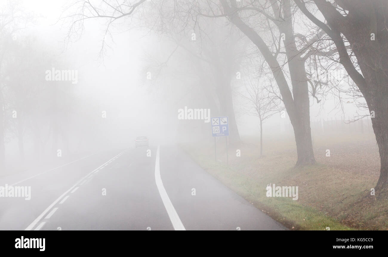 Car driving the Fog Road background Stock Photo - Alamy