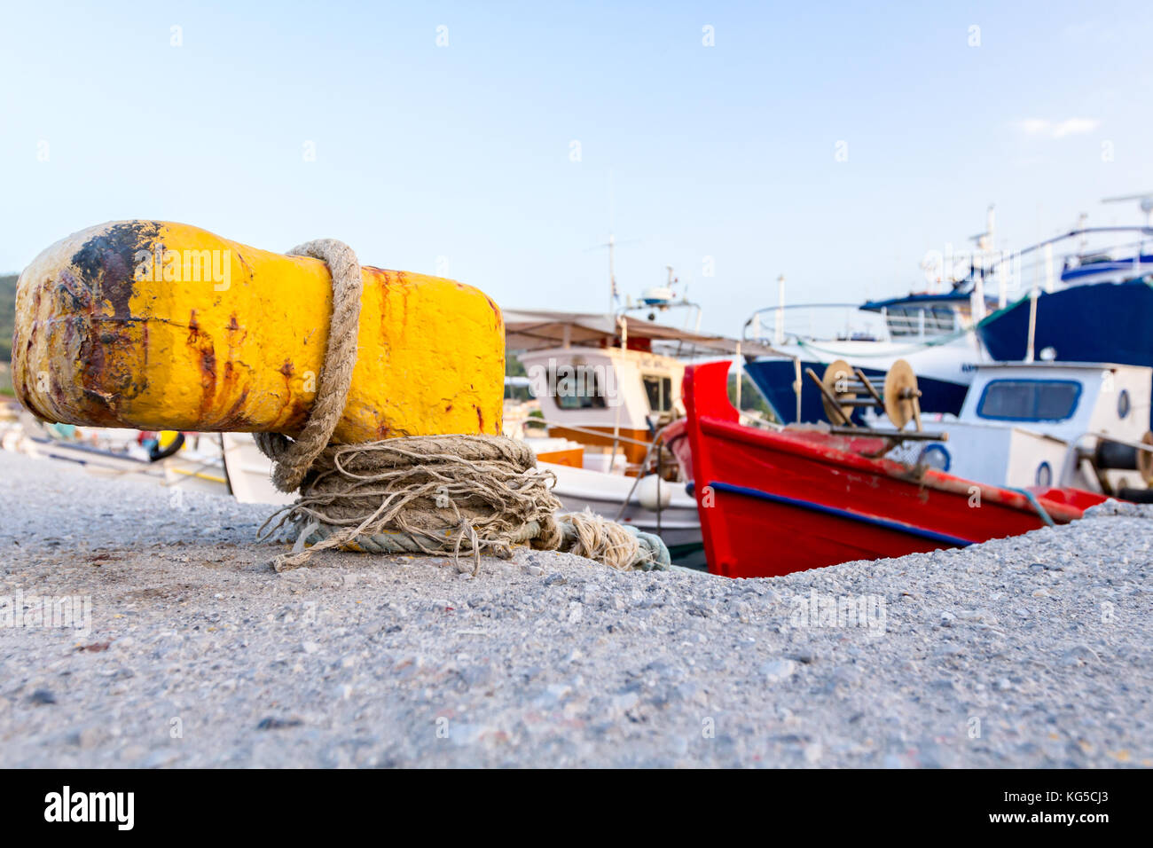Docked colorful fishing boats tied with rope to a moor at the local ...