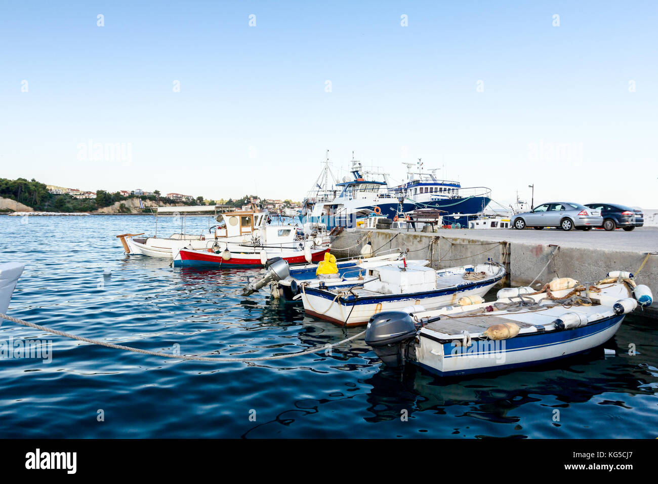 Docked boats are tied with ropes to the moor at the local port Stock ...