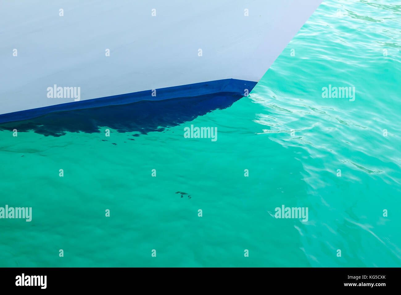 Bow of a small wooden fishing boat floating on a quiet water surface ...