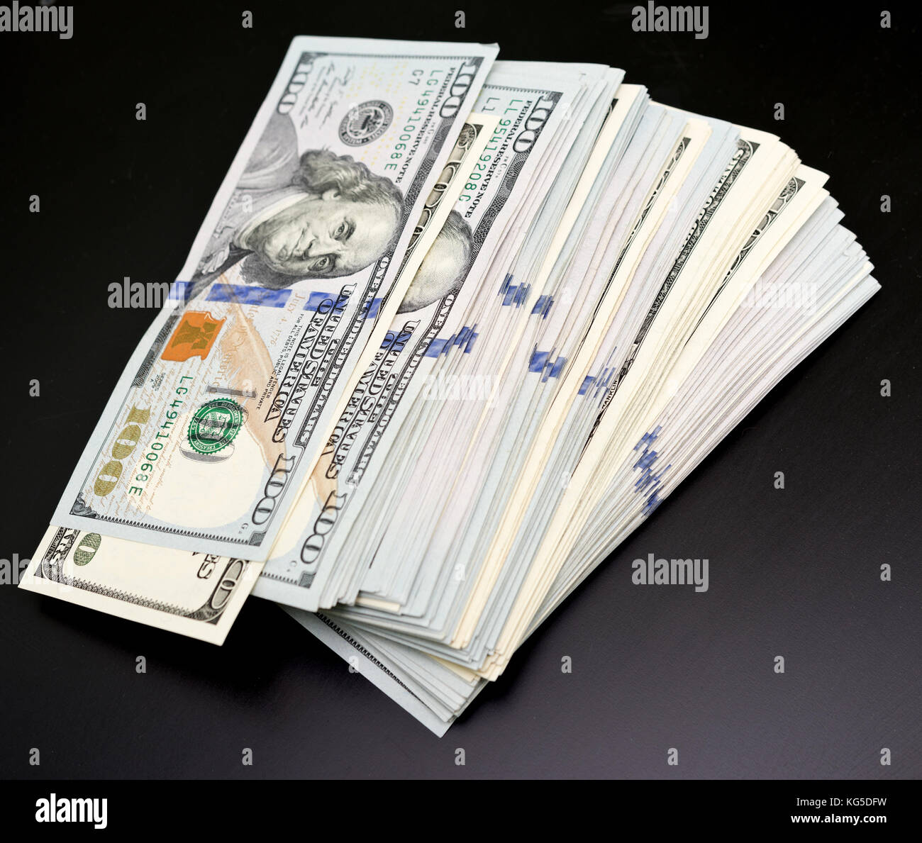 Stack of one hundred dollars on a black background Stock Photo - Alamy
