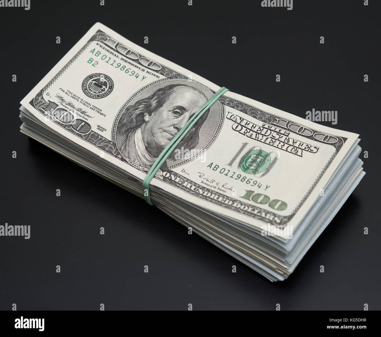 Stack of one hundred dollars on a black background Stock Photo - Alamy