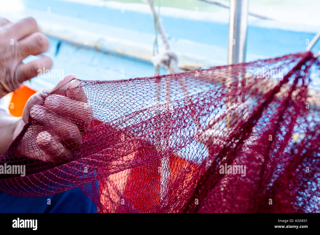 Needle with thread in fisherman hands repairing net for angling Stock ...