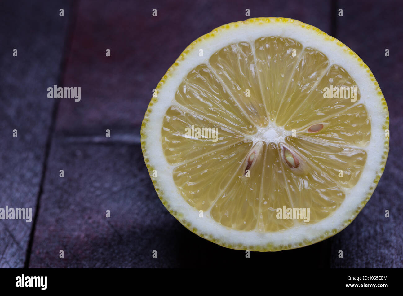 Lemon cut open on mahogany wooden background Stock Photo - Alamy