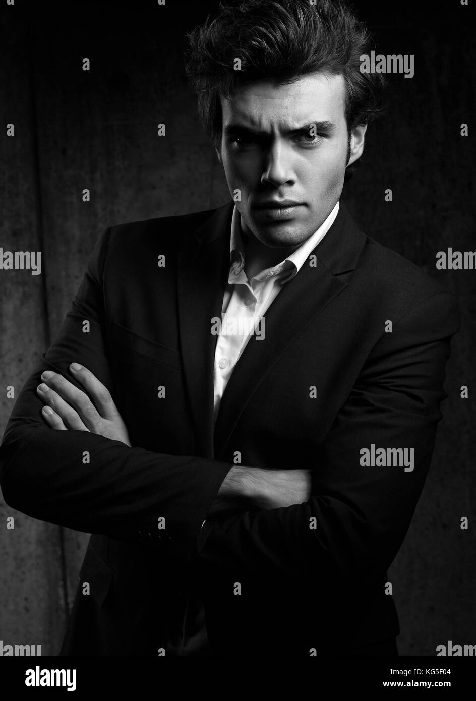 Charismatic business handsome male with folded arms in blue fashion ...