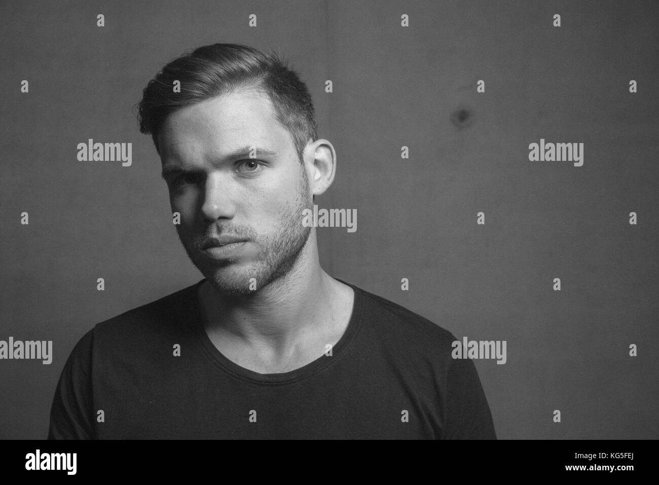 Young man, serious, looking into camera, portrait Stock Photo - Alamy